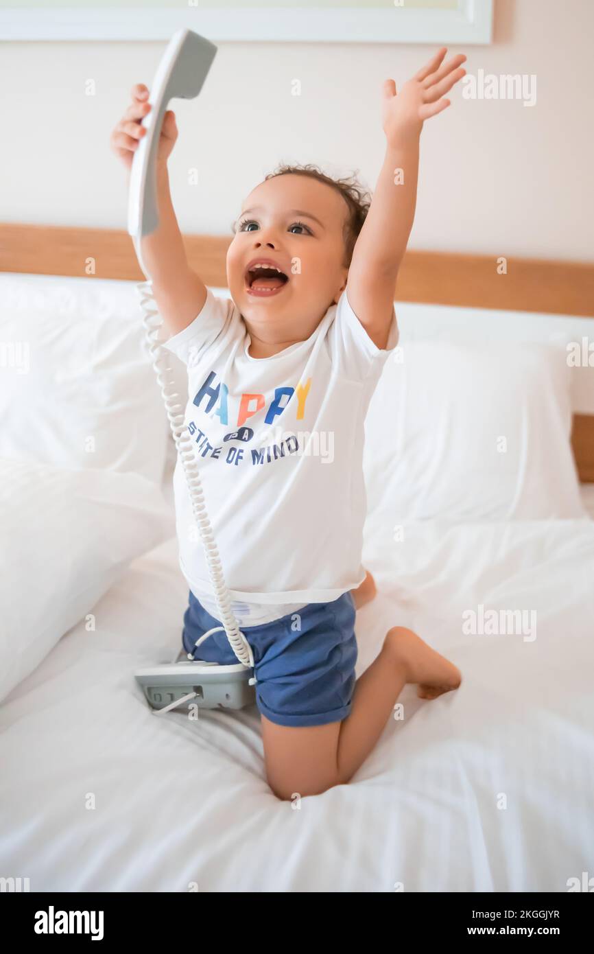 Happy kid calling on a push-button telephone in hotel room Stock Photo ...