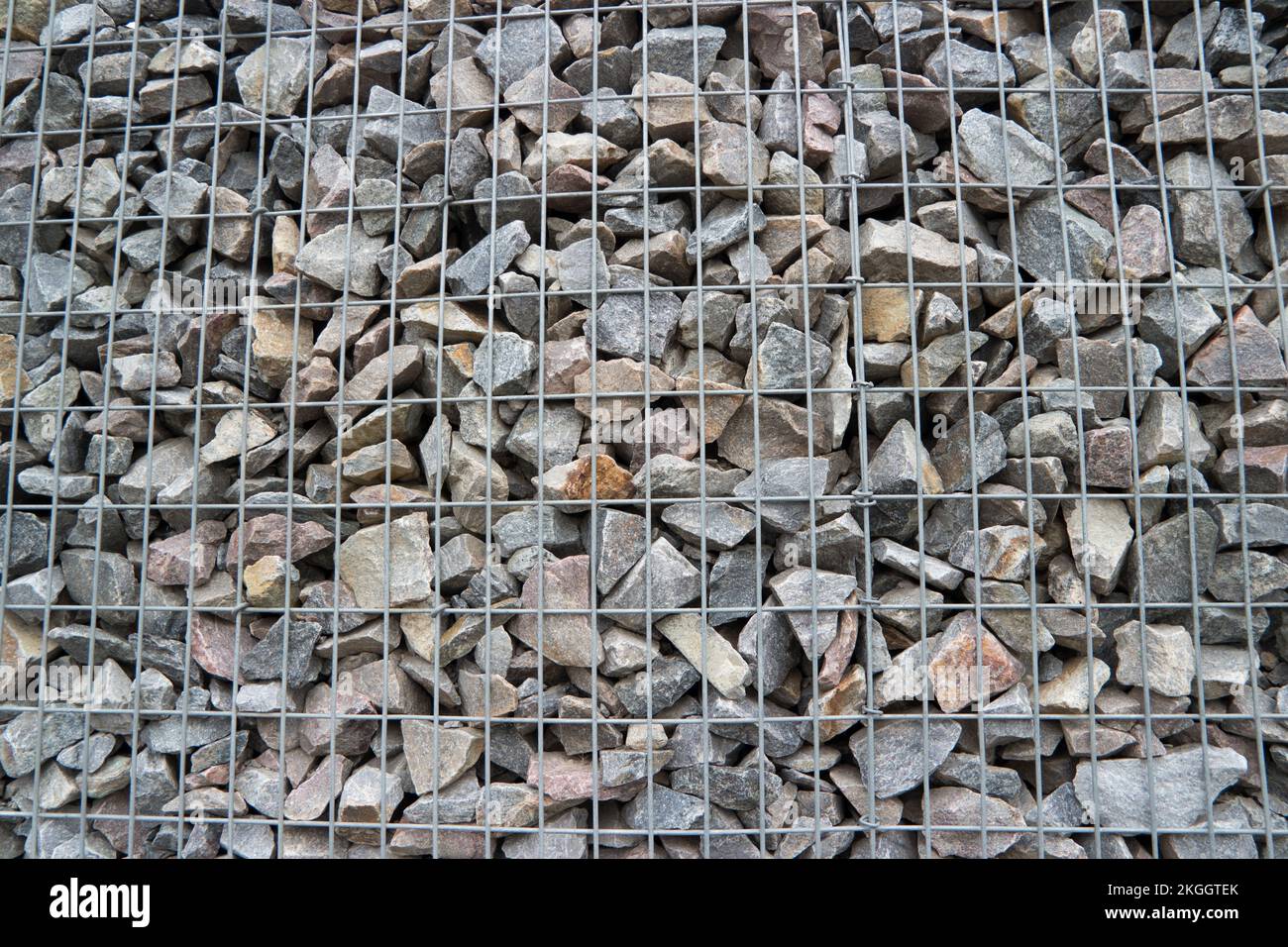 Natural stone wall with stones and metal framework Stock Photo - Alamy