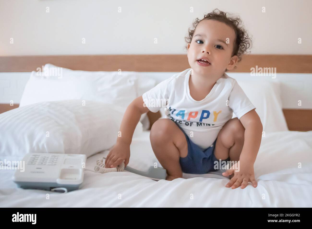 Happy kid calling on a push-button telephone in hotel room Stock Photo ...