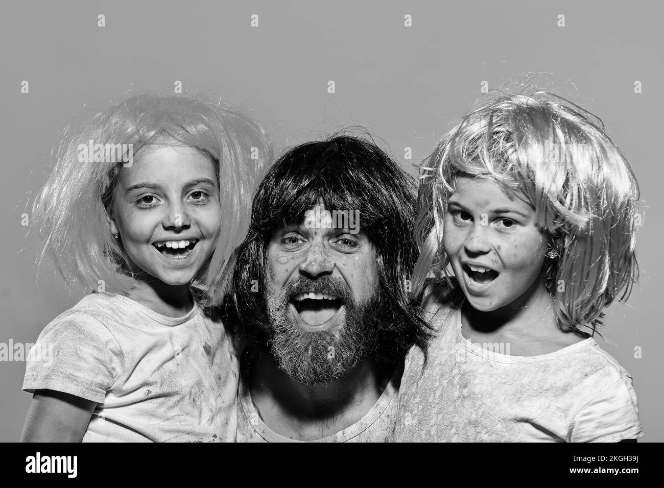 Kids and bearded man wear wigs. Art and fun concept Stock Photo - Alamy