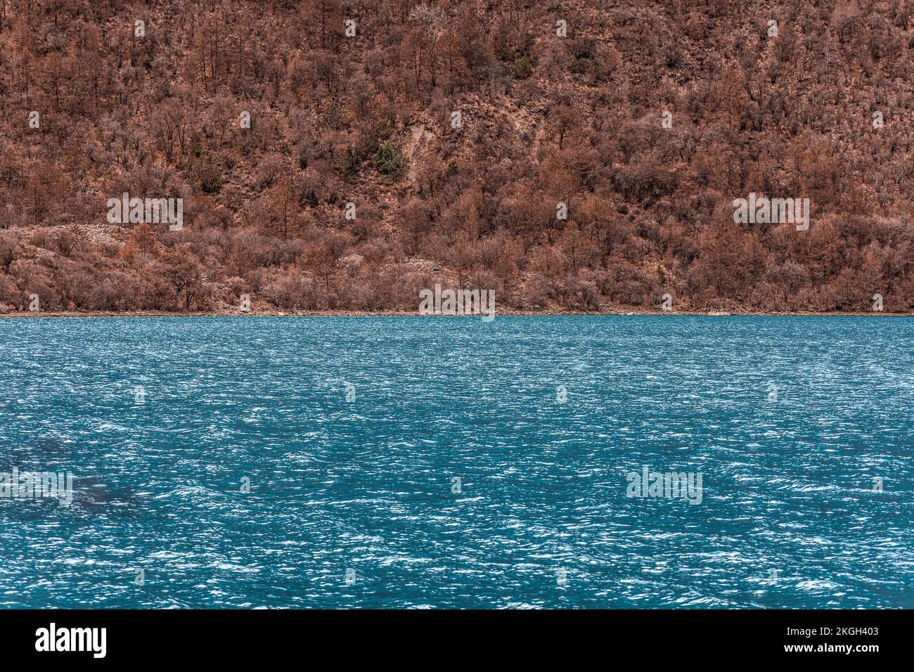 A symmetrical landscape of a blue lake and a brown landscape Stock ...