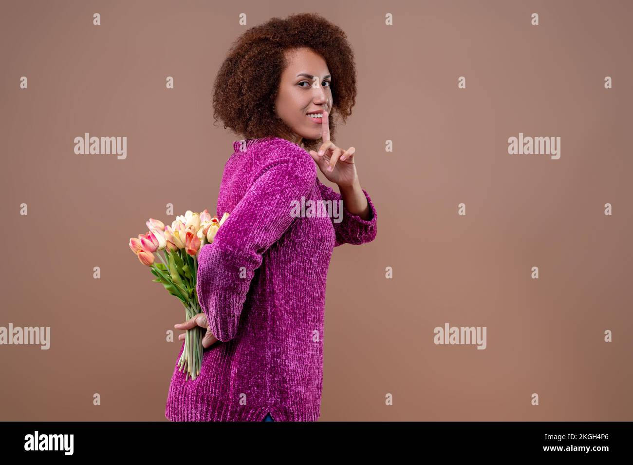 Smiling pretty young woman holding a bunch of flowers Stock Photo - Alamy