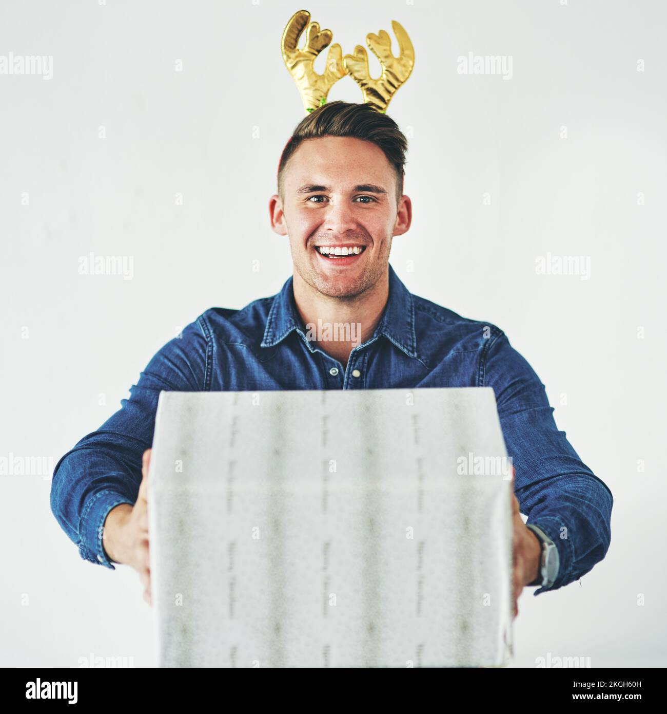 Christmas, present and celebration with a festive man in studio on a ...