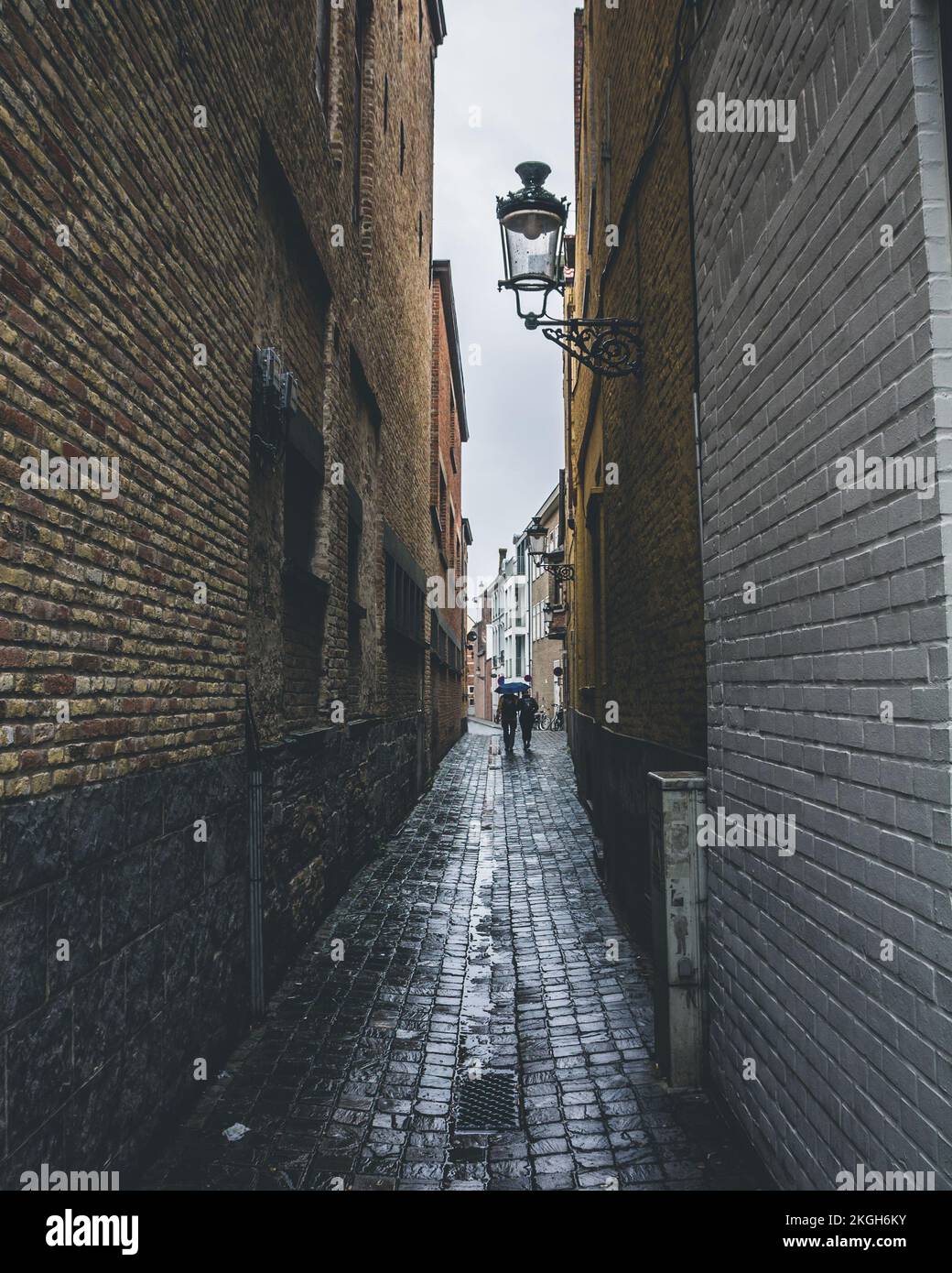 A narrow street between brick buildings in a city Stock Photo - Alamy