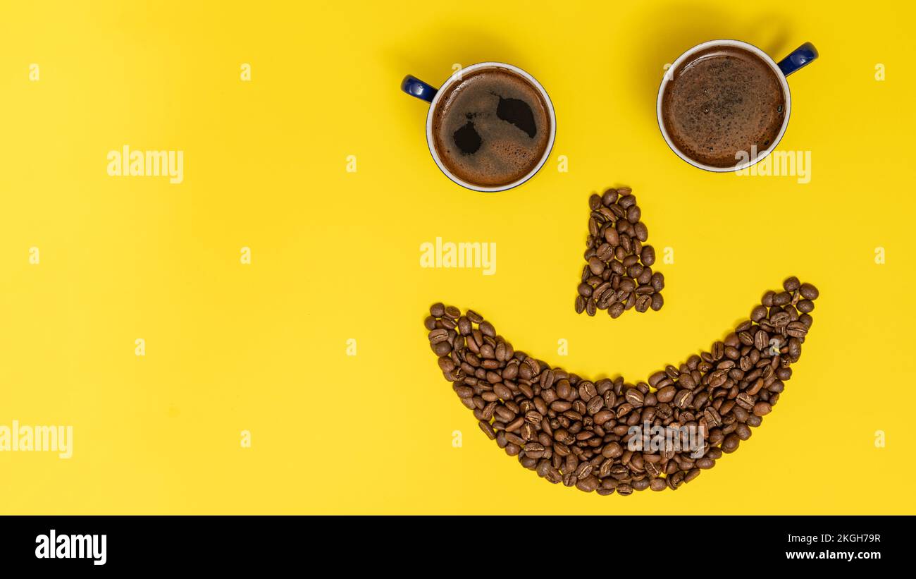 Smiling emoticon, lips made of coffee beans and eyes made of coffee ...