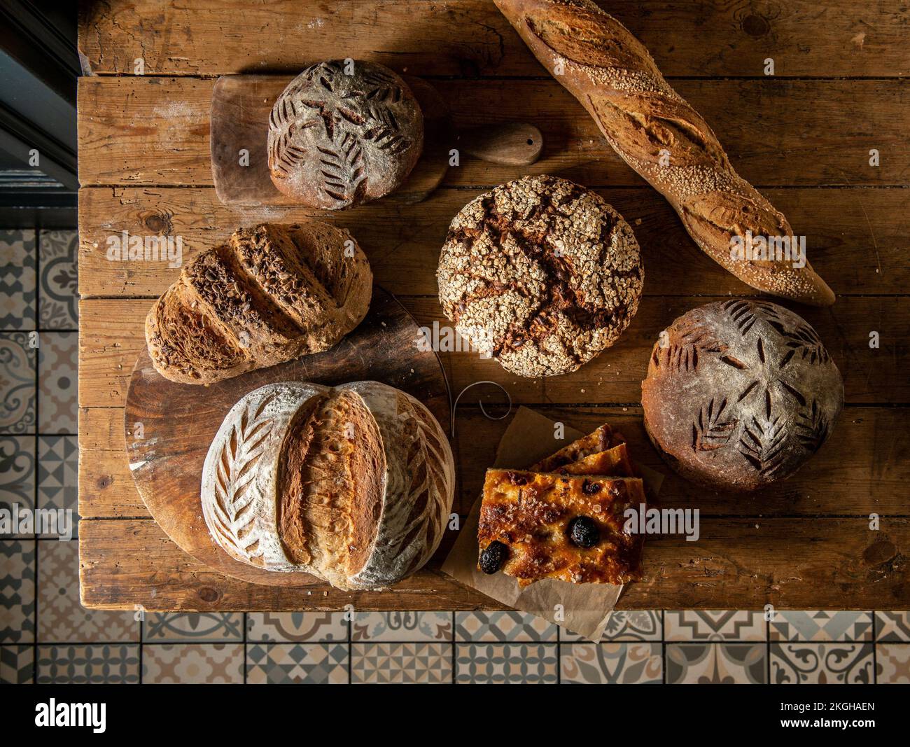 A top view of different types of sourdough bread on a wooden board ...