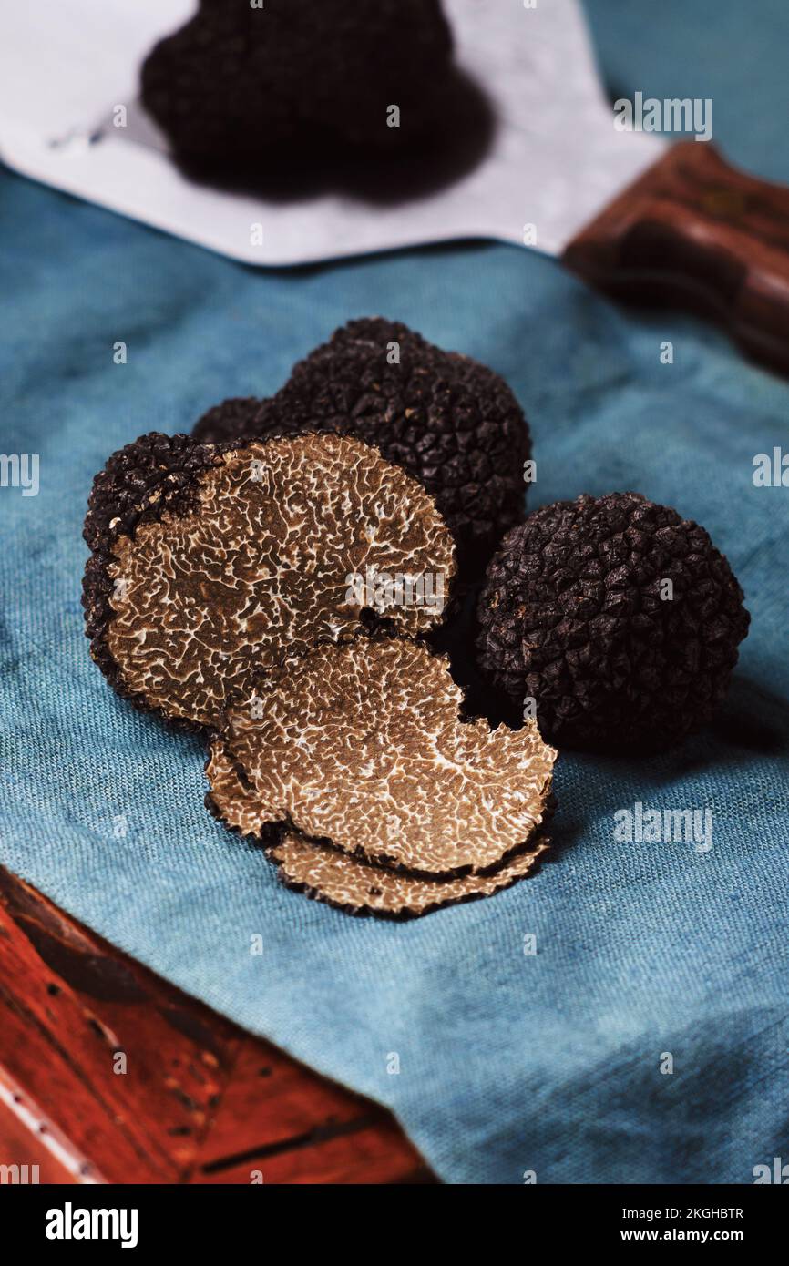 Cut black truffles on dark brown vintage background. Selective focus ...