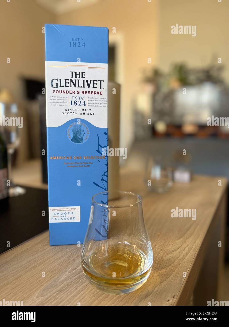 A vertical shot of a glass and bottle of Glenlivet blue whiskey Stock ...
