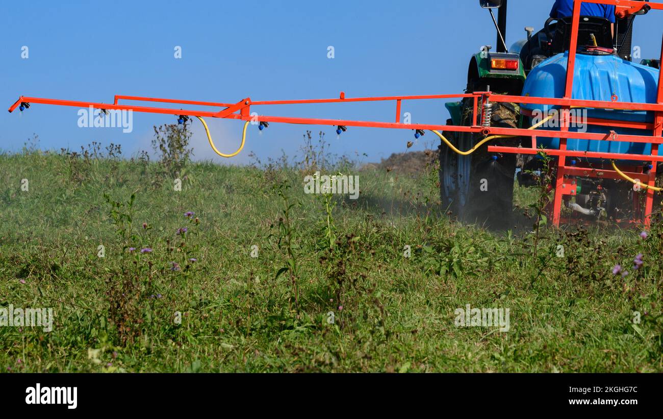 A tractor with a tank and attached equipment for spraying the field ...