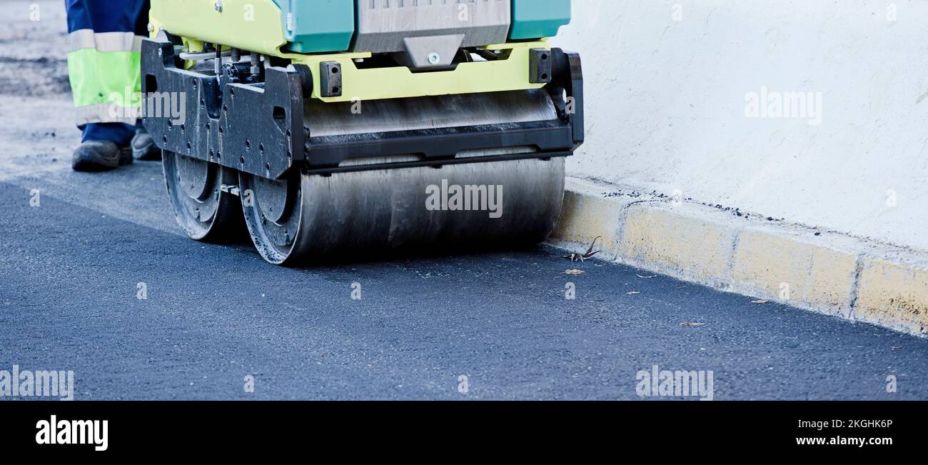 Road construction equipment flattening and smoothing asphalt black top ...