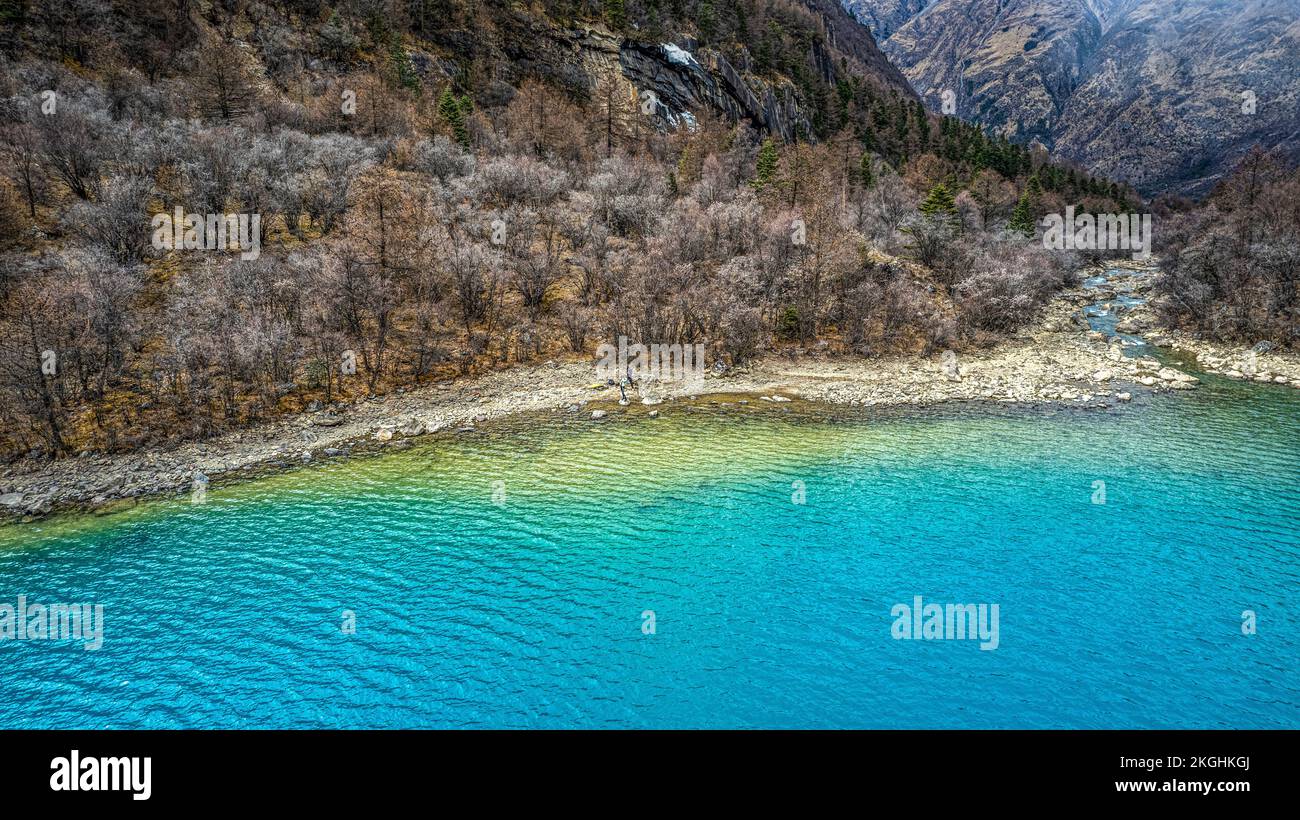 An aerial of the separation of the blue Haba lake and a brown woodland ...