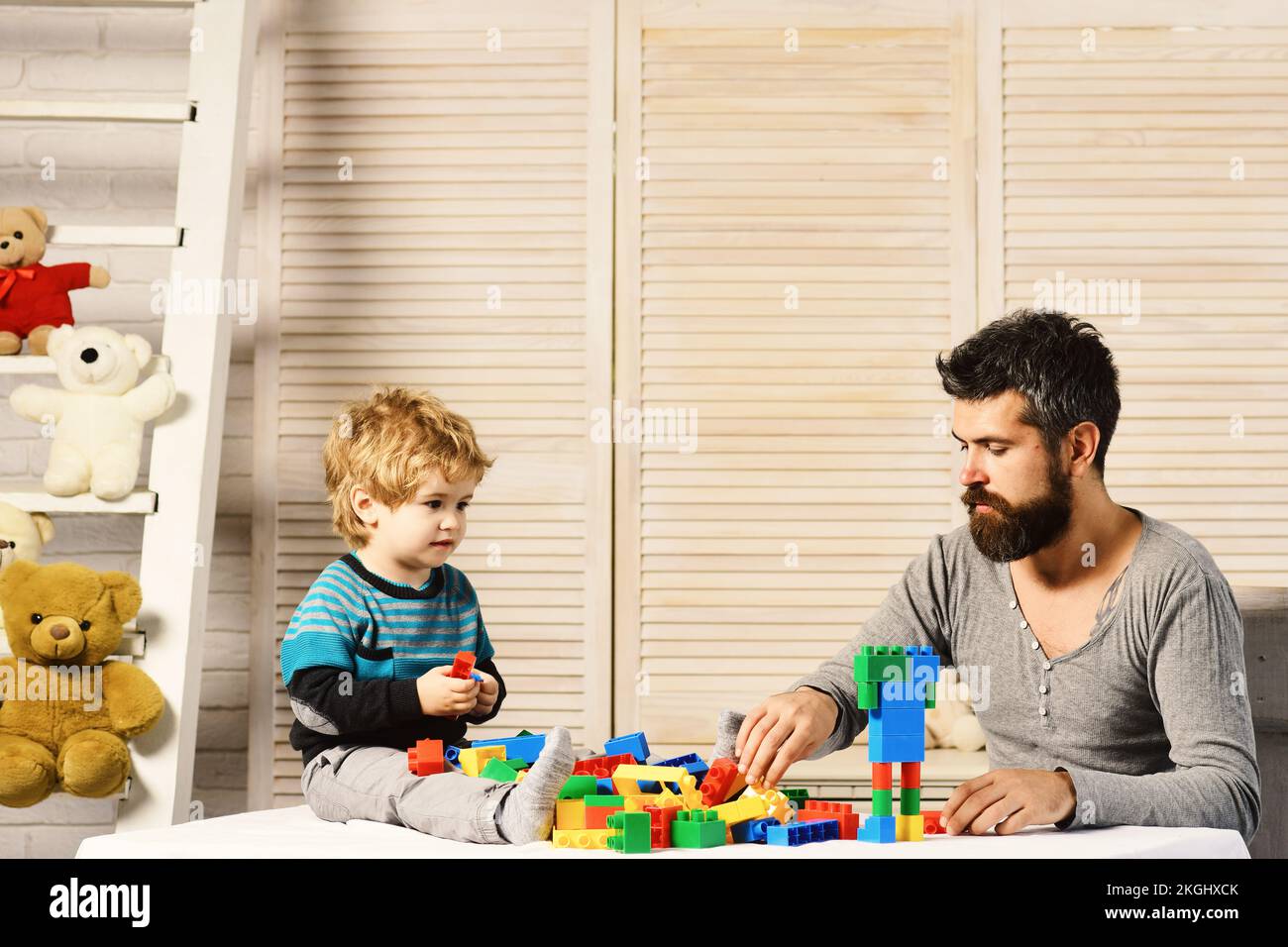 Dad and kid build of plastic blocks. Father and son Stock Photo - Alamy