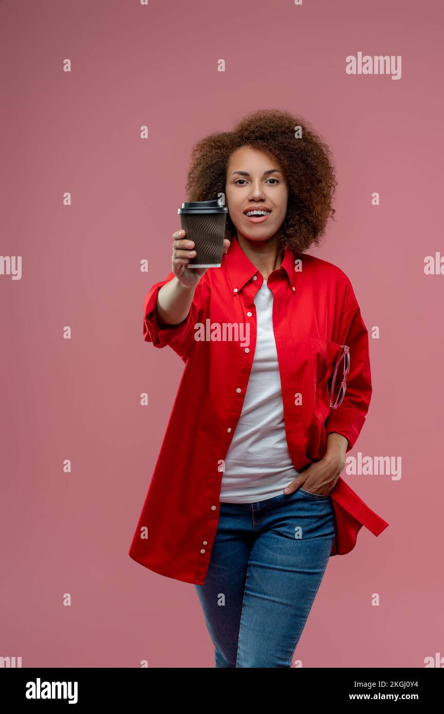 Pretty curly-haired woman in red jacket having a coffee break Stock ...