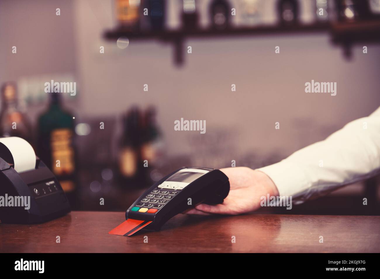 Cashiers hand holds credit card reader on defocused background Stock ...