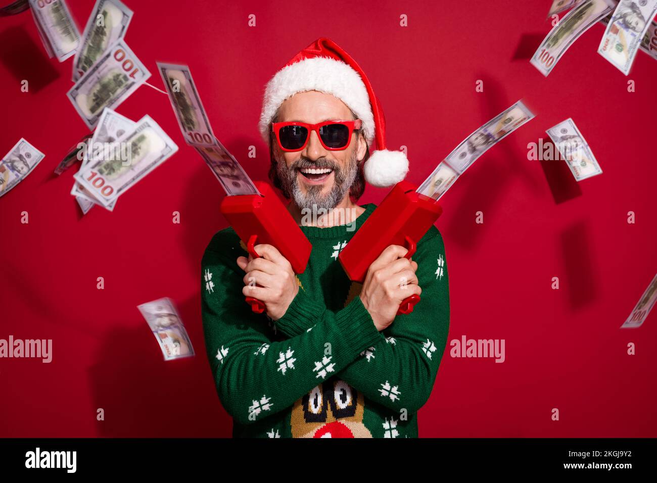 Portrait of positive cheerful man crossed hands hold money gun shooting ...