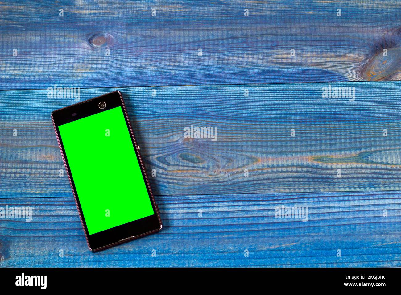 smartphone phone with green screen on wooden table Stock Photo - Alamy