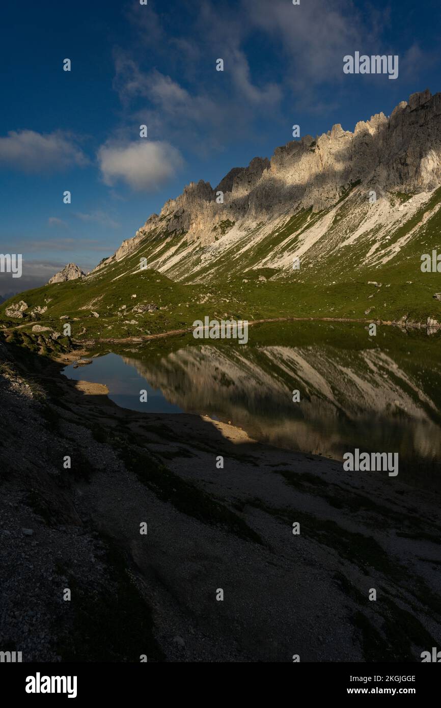 Scenic mountain slope reflecting on the Olbe Lakes water surface, Italy ...