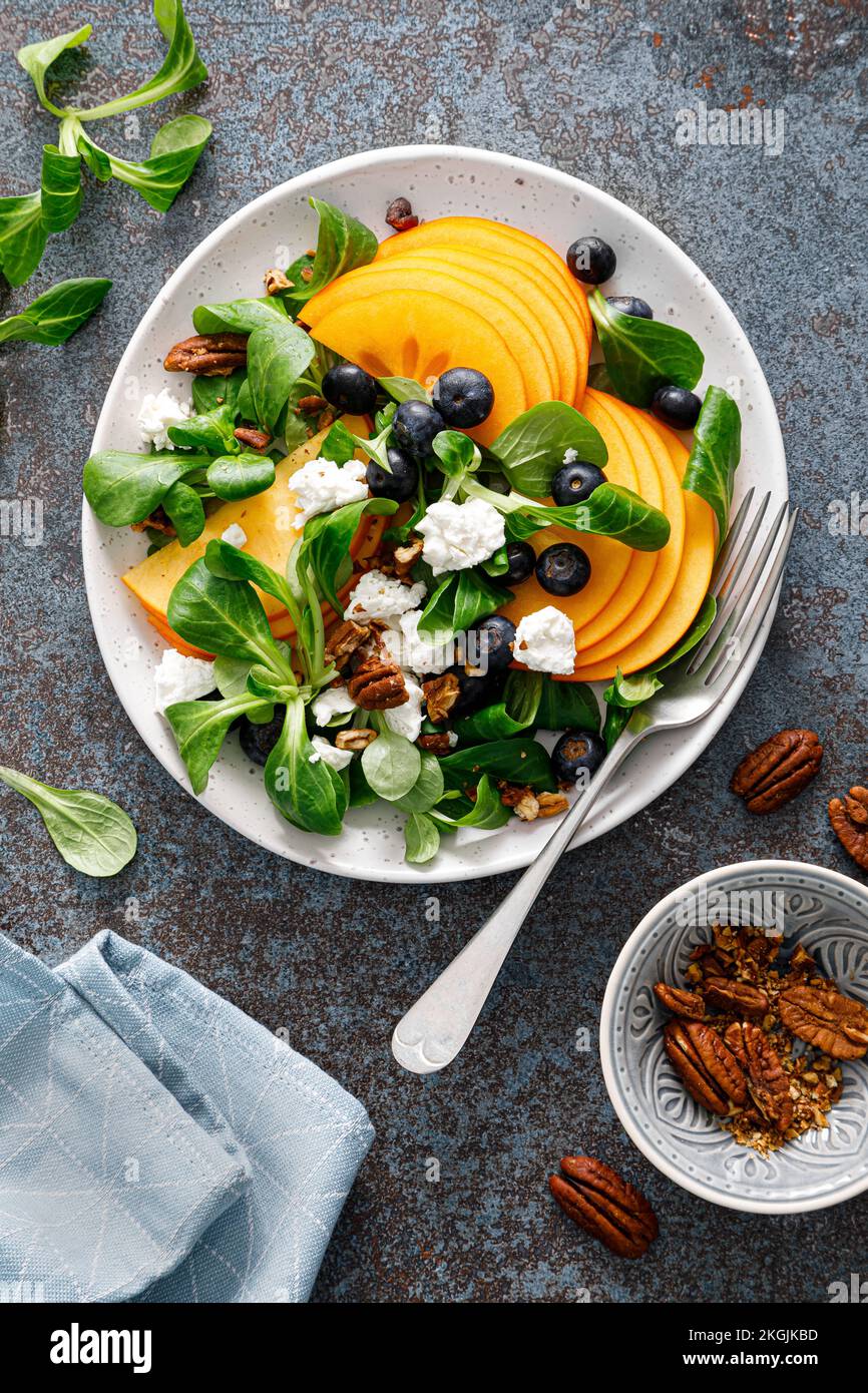 Persimmon fruit salad with blueberry, pecan nuts and ricotta chesse ...
