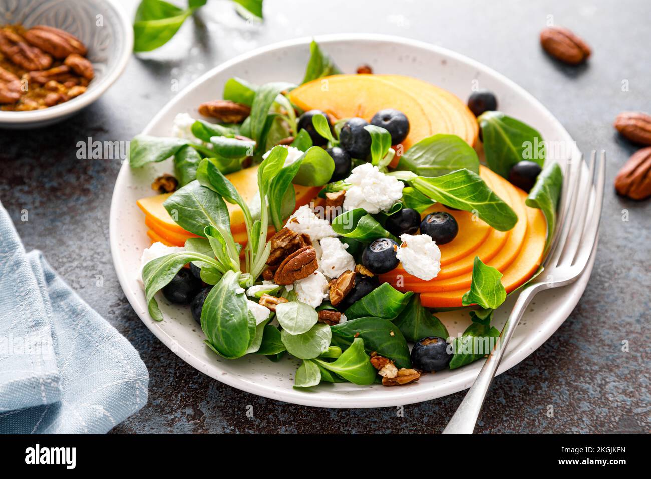 Persimmon fruit salad with blueberry, pecan nuts and ricotta chesse ...