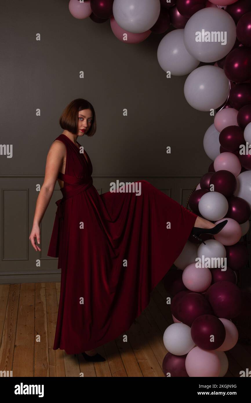 Women in a red dress and high heels stepping on a balloon Stock Photo ...