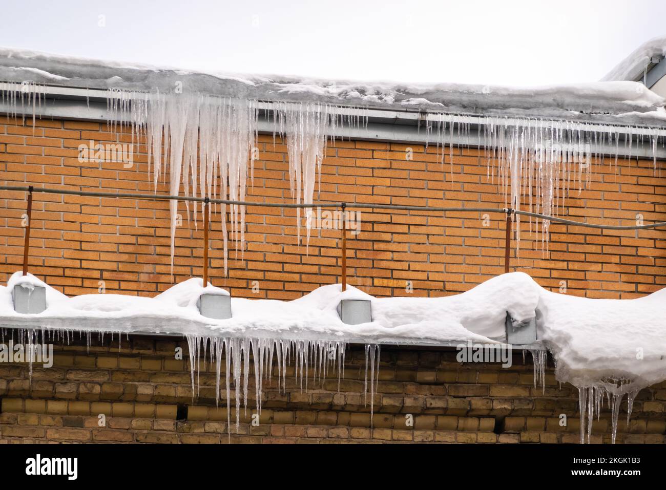 Sharp icicles hanging on the edge of the roof. Melting snow forms icicle Stock Photo - Alamy