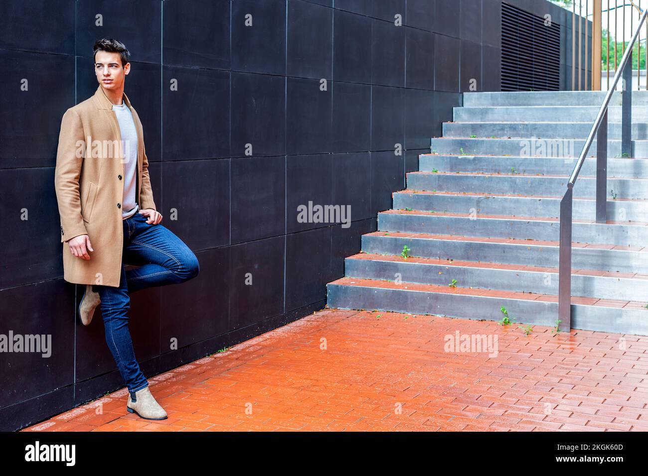 Young man wearing winter clothes in the street. Young guy with modern ...