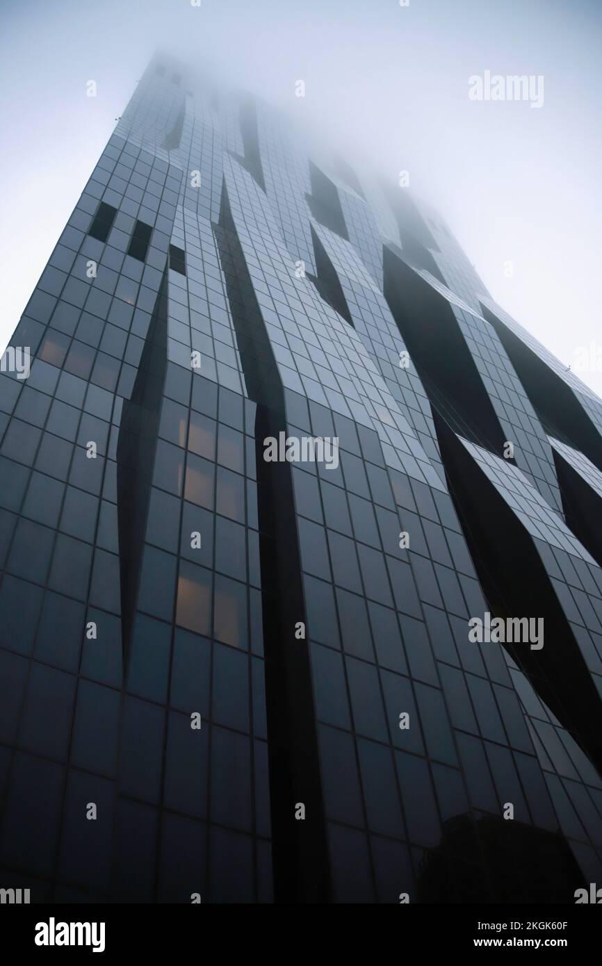 Front part (tilted) of a modern skyscraper covered in fog in Vienna ...