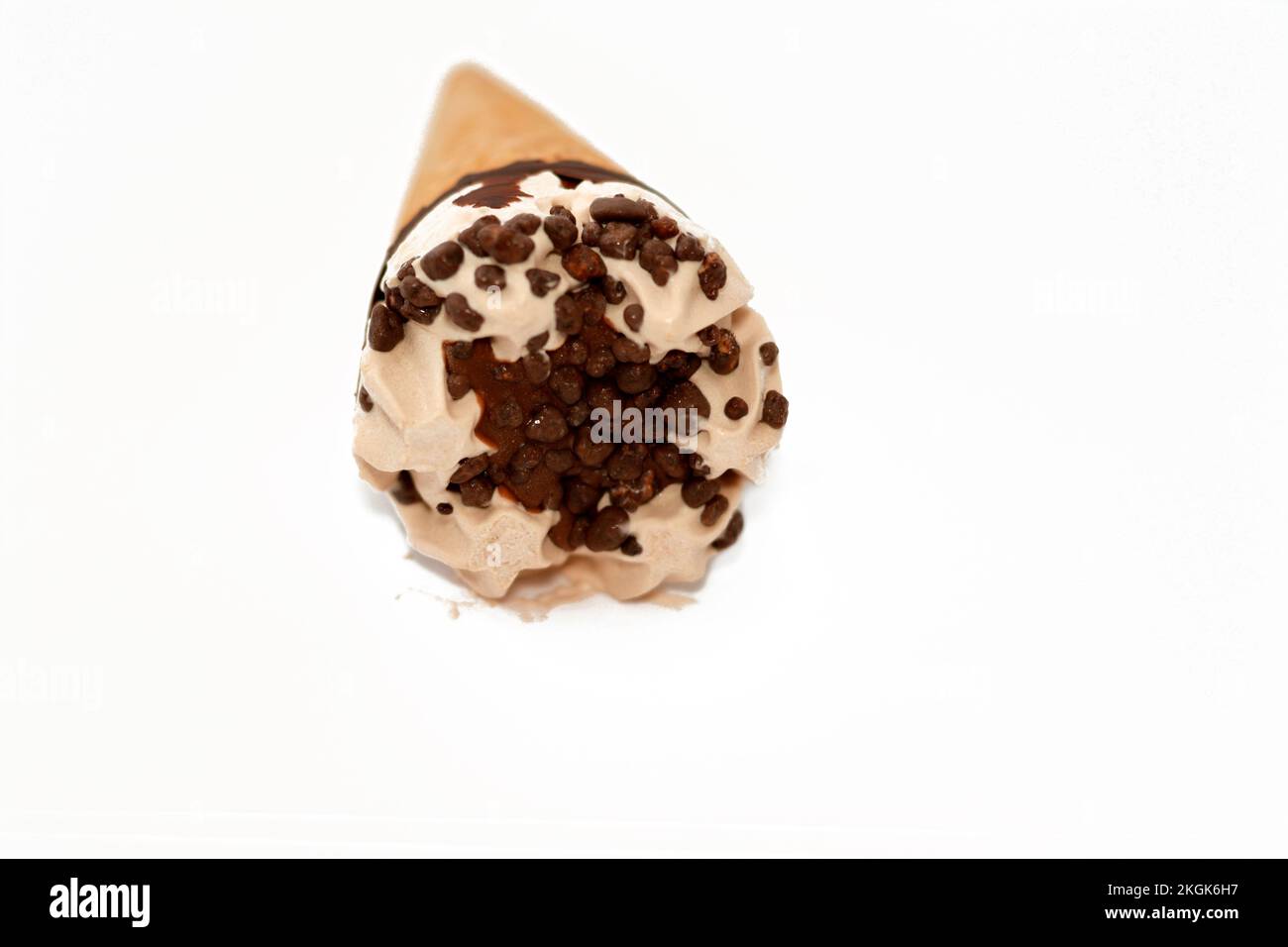 Ice cream vanilla cone with topping of chocolate chips pieces in a ...