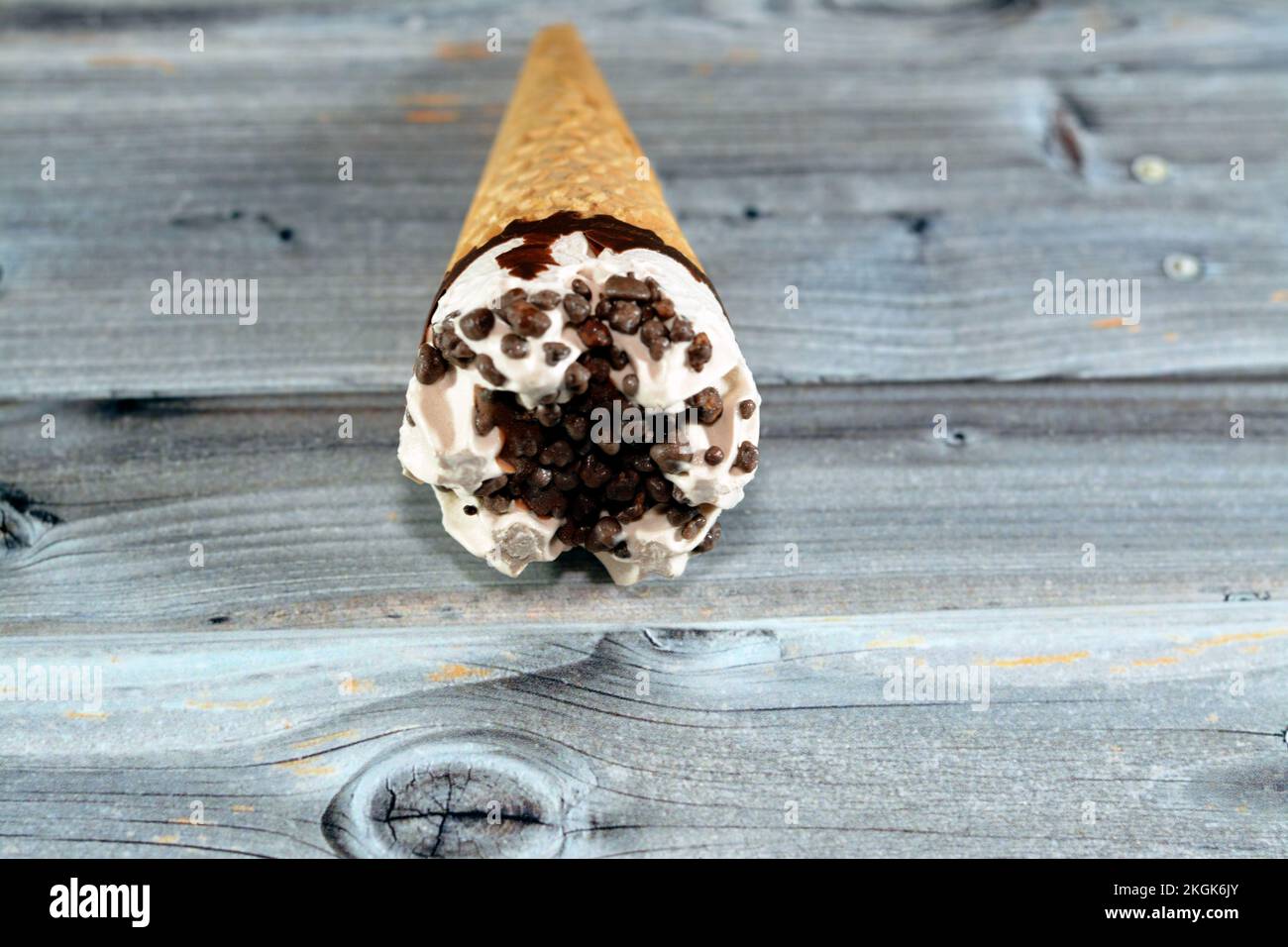 Ice cream vanilla cone with topping of chocolate chips pieces in a ...