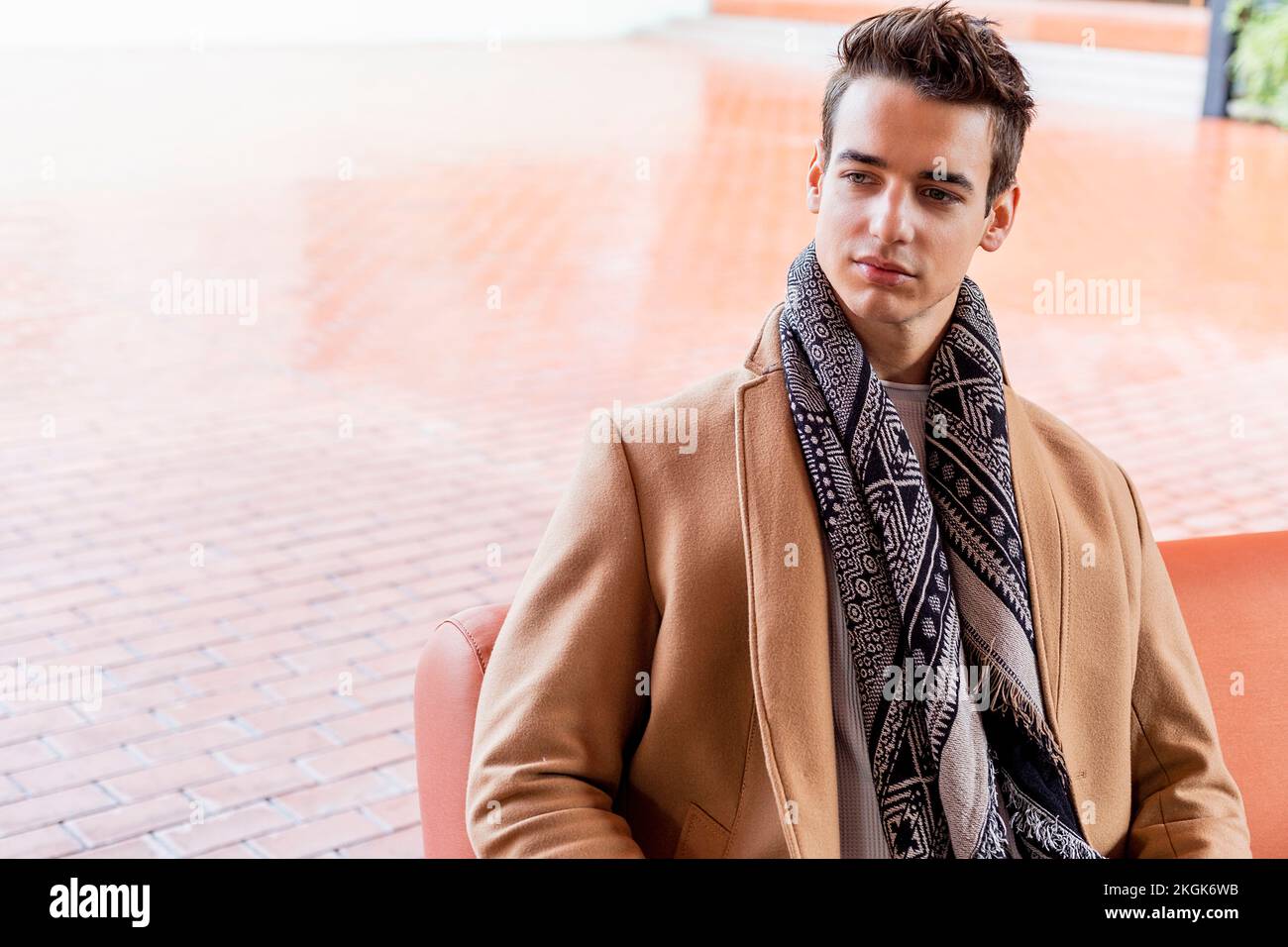 Young man wearing winter clothes in the street. Young guy with modern ...