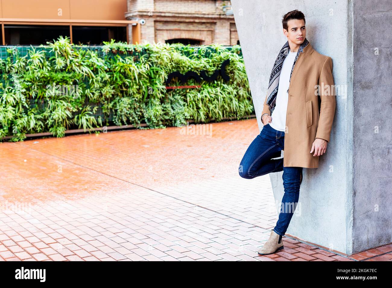 Young man wearing winter clothes in the street. Young guy with modern ...