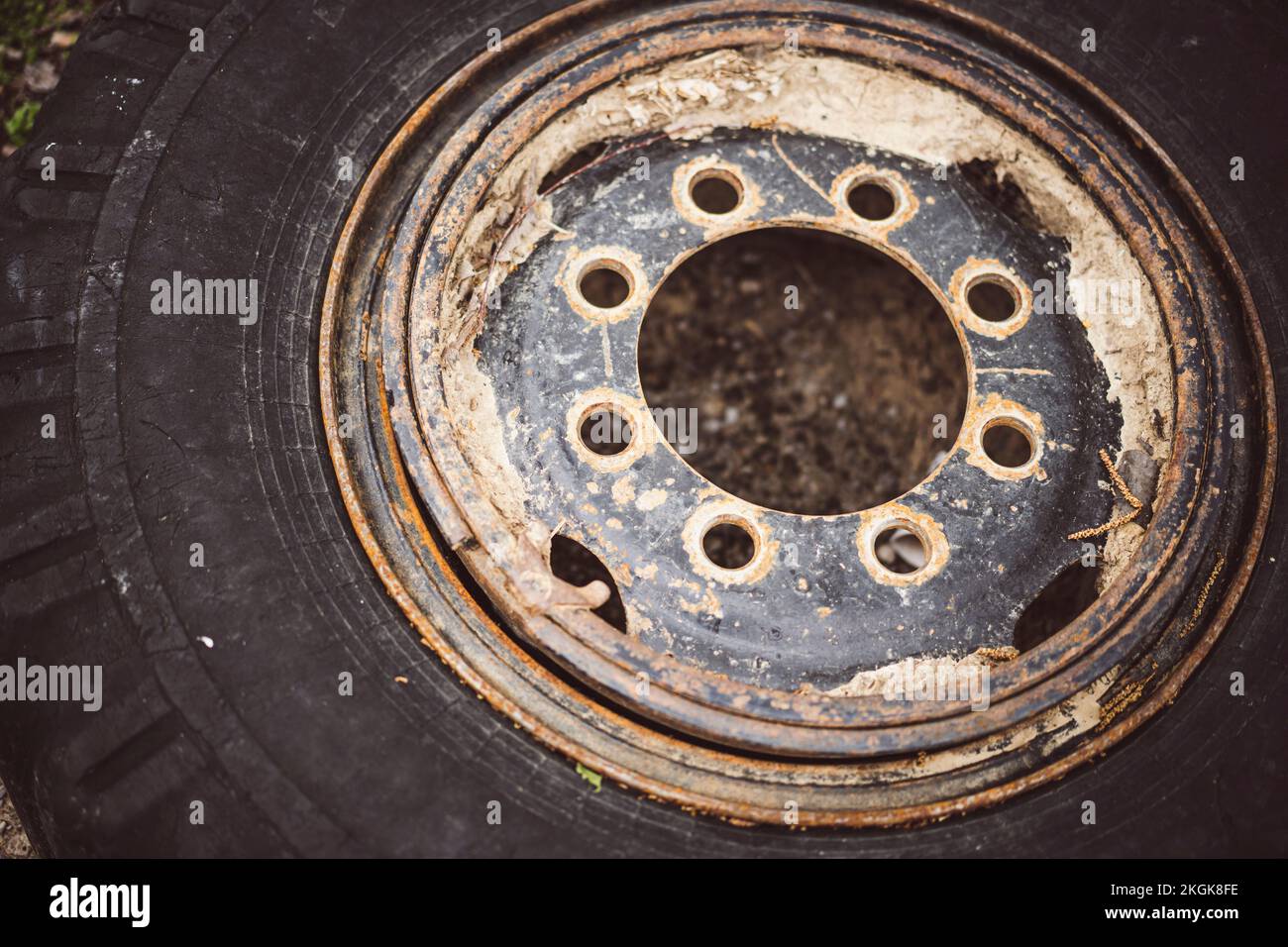 Detail of the used wheel of a truck, with a rusty rim and worn out tire ...