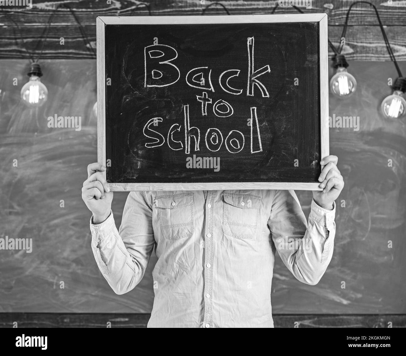 Start of school year concept. Teacher faceless holds blackboard with ...