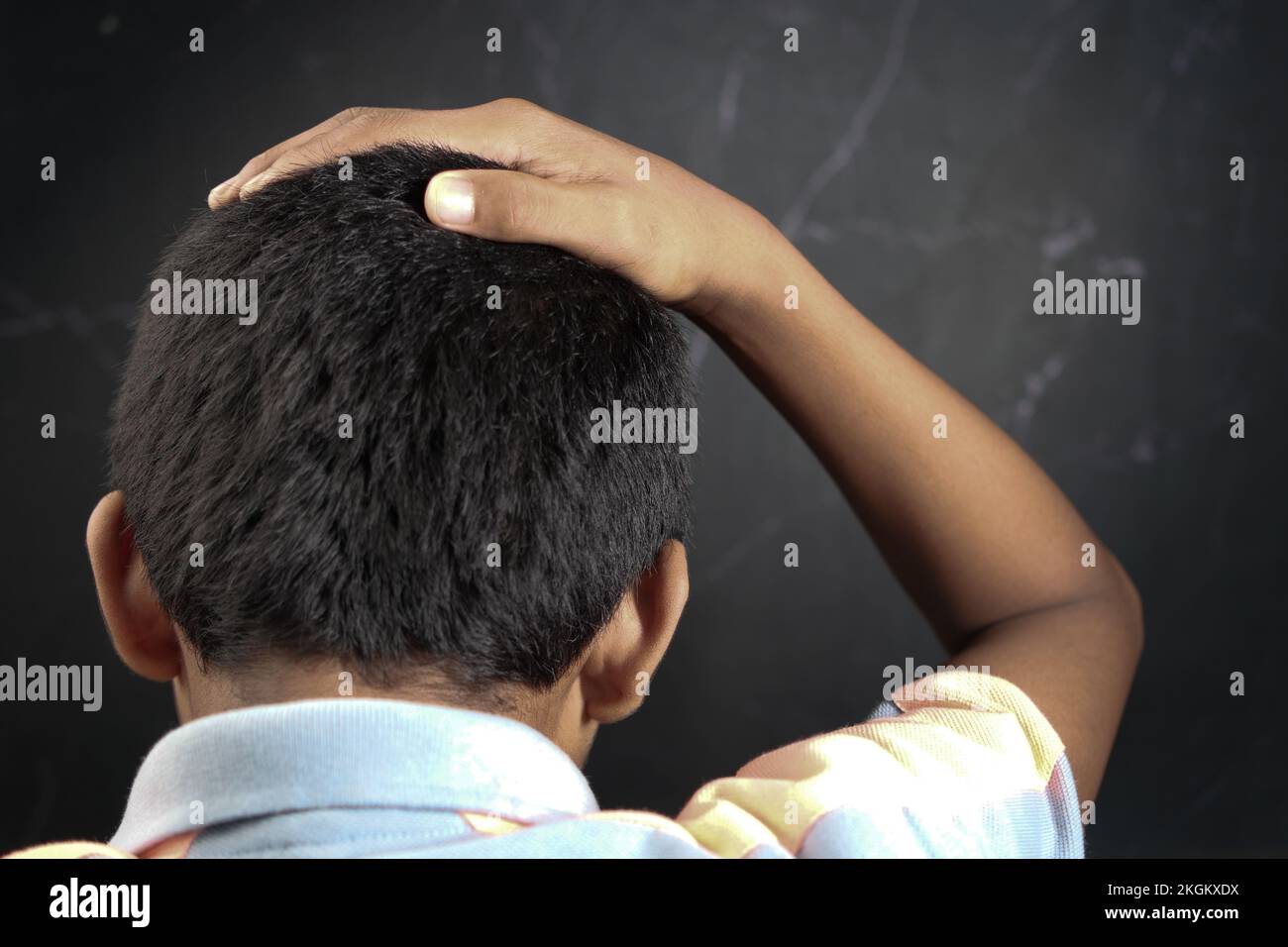 teenage boy Scratching Head Against black background Stock Photo - Alamy