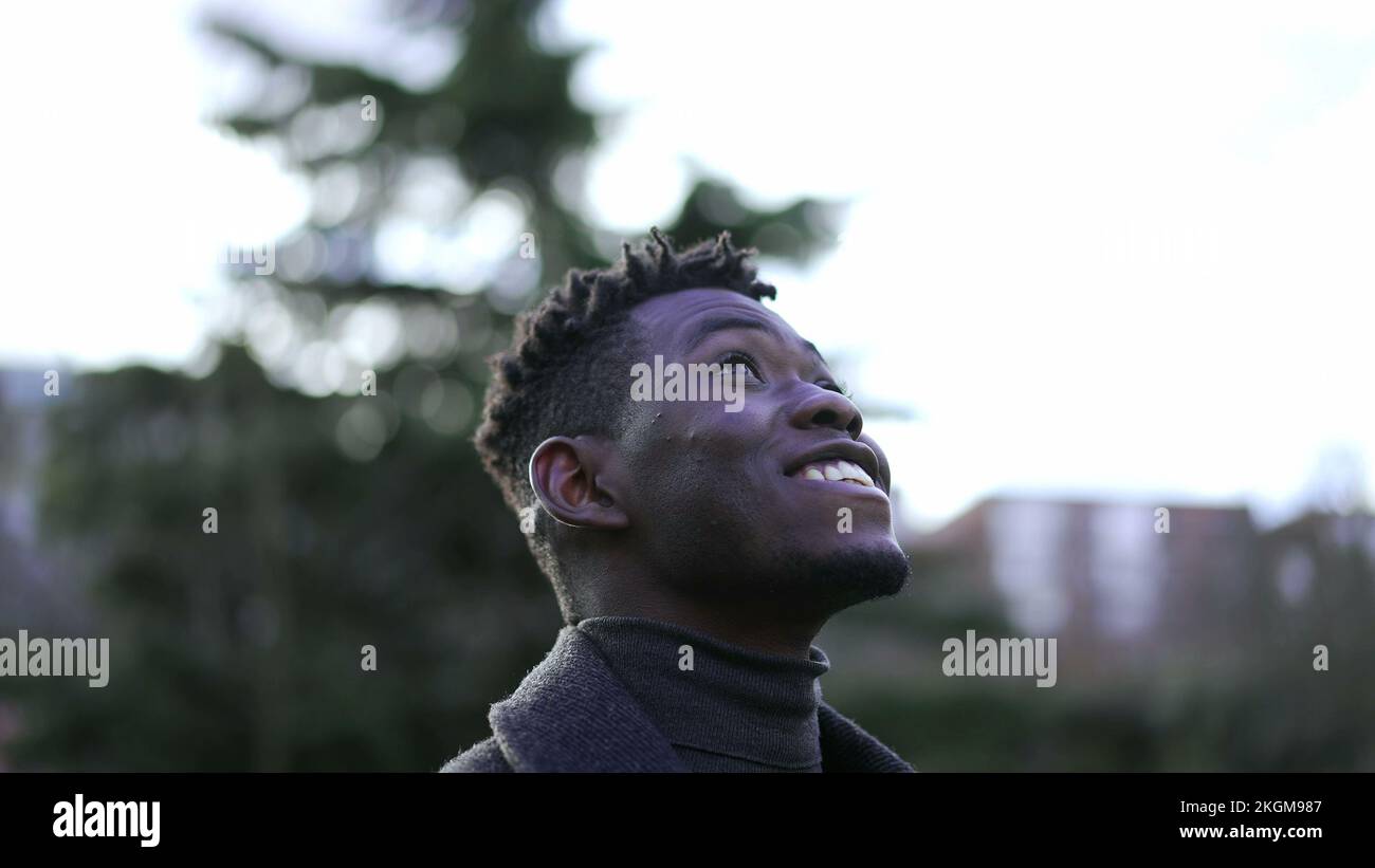 Young black man closing and opening eyes in meditation and ...