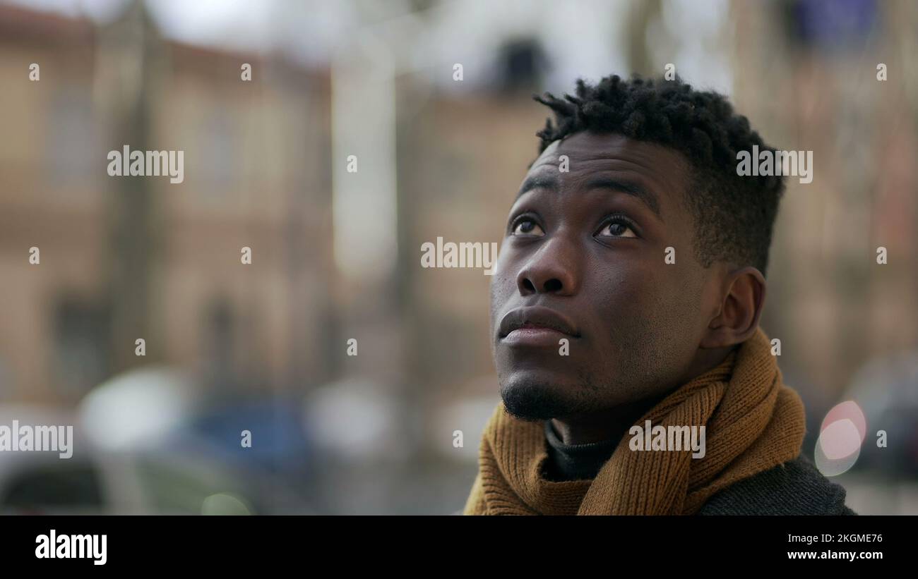 Thoughtful black man standing outside close-up face portrait in city ...