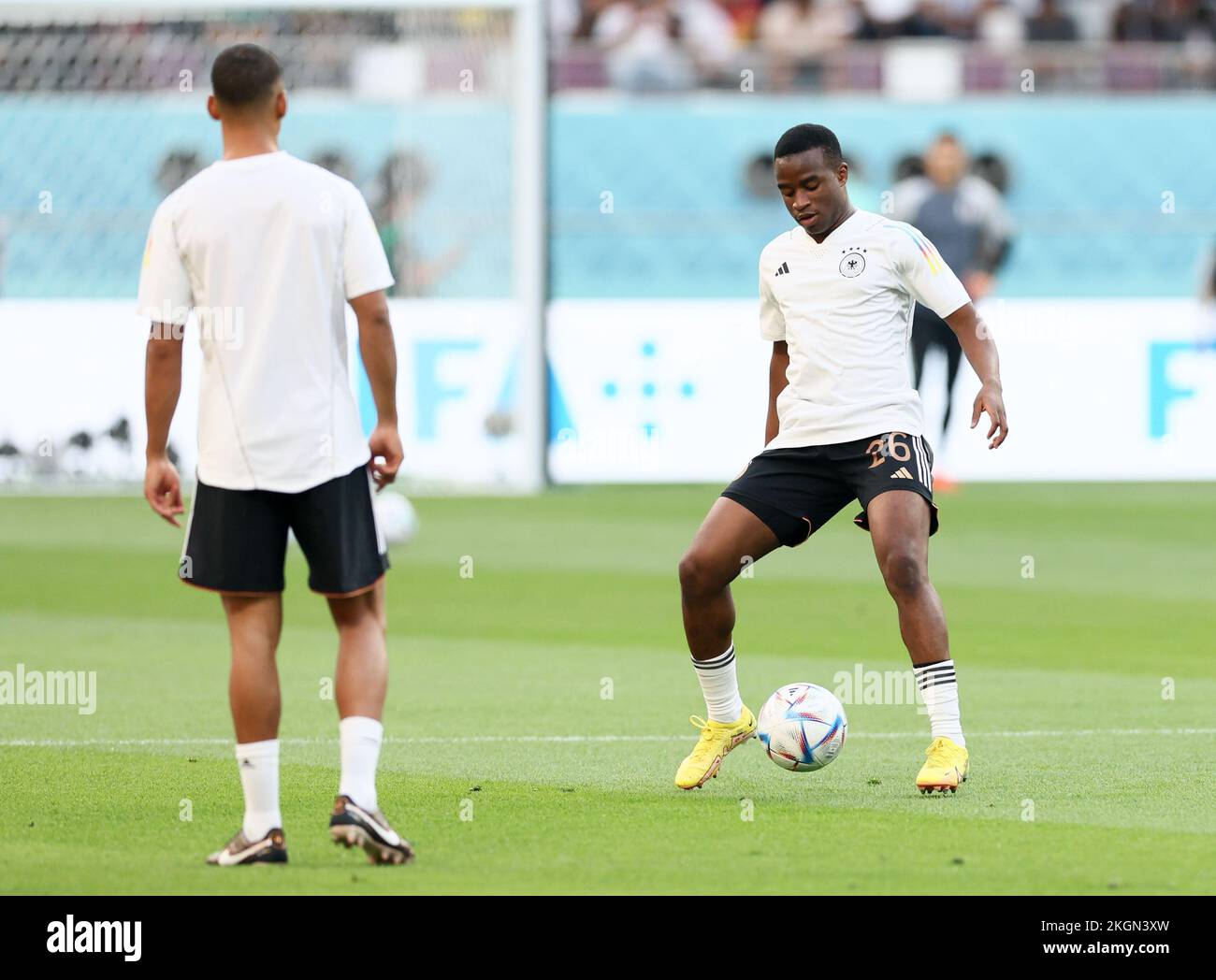 Doha, Qatar. 23rd Nov, 2022. Youssoufa Moukoko (R) of Germany warms up ...