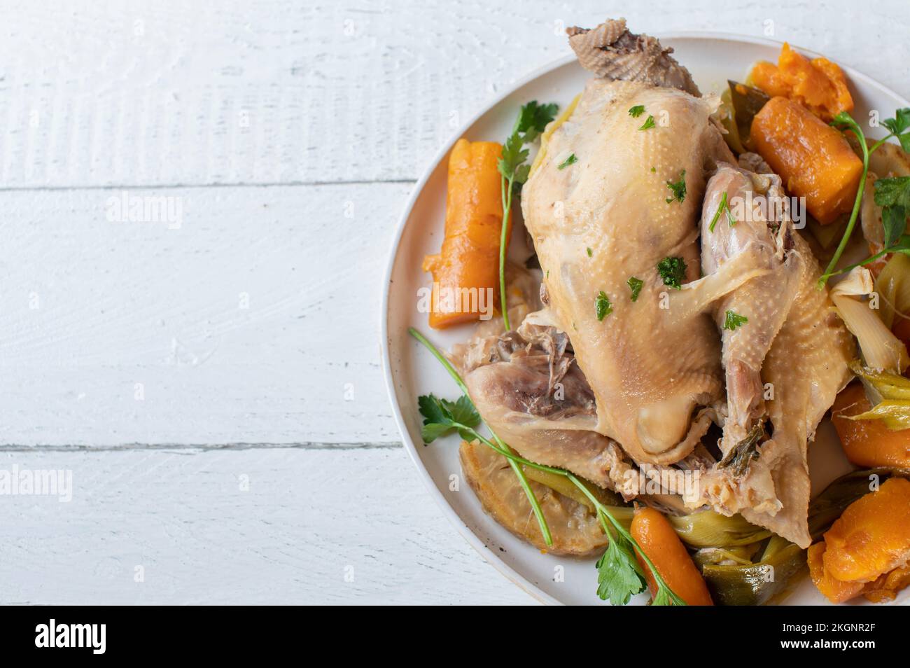 Fresh cooked boiled hen with root vegetables on light background from ...