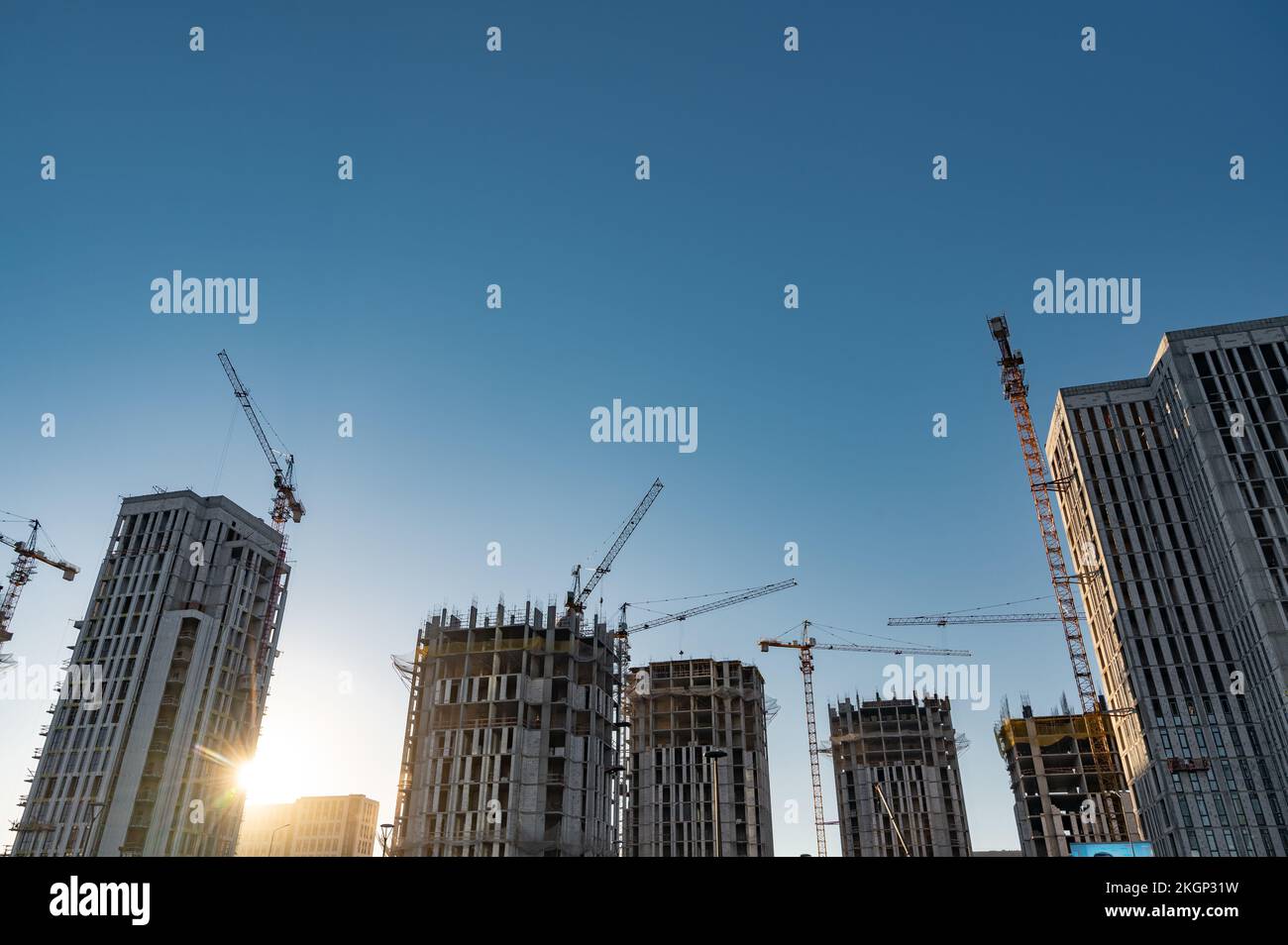 Tall buildings under construction and cranes under a blue sky Stock ...