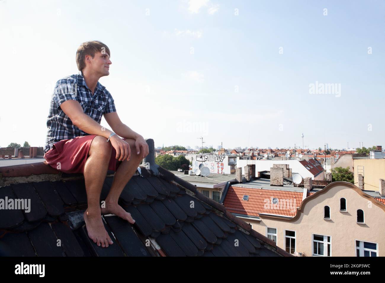 Germany, Berlin, Man sitting on roof Stock Photo - Alamy