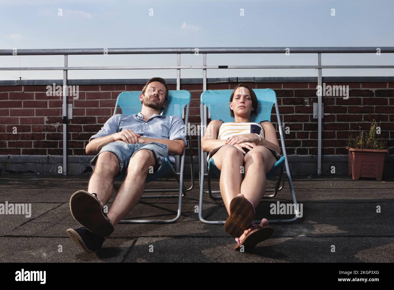 Germany, Berlin, Couple relaxing on roof terrace Stock Photo - Alamy