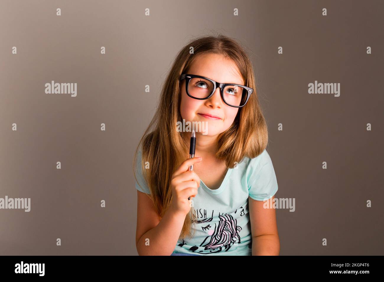 Portrait of smart girl with oversized glasses thinking Stock Photo - Alamy