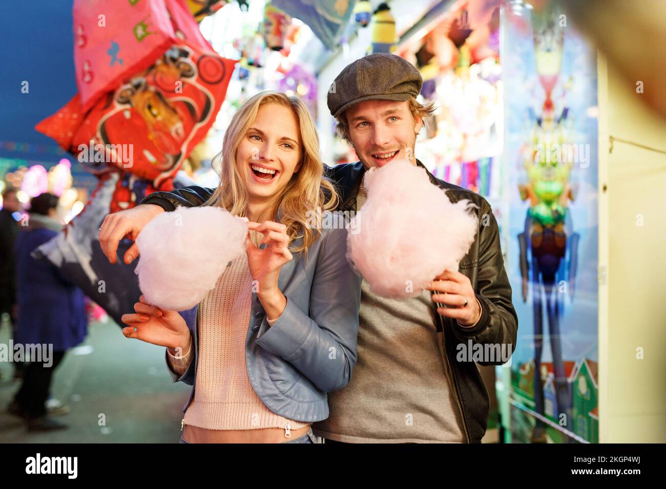 Young couple at fun fair eating candy floss Stock Photo - Alamy