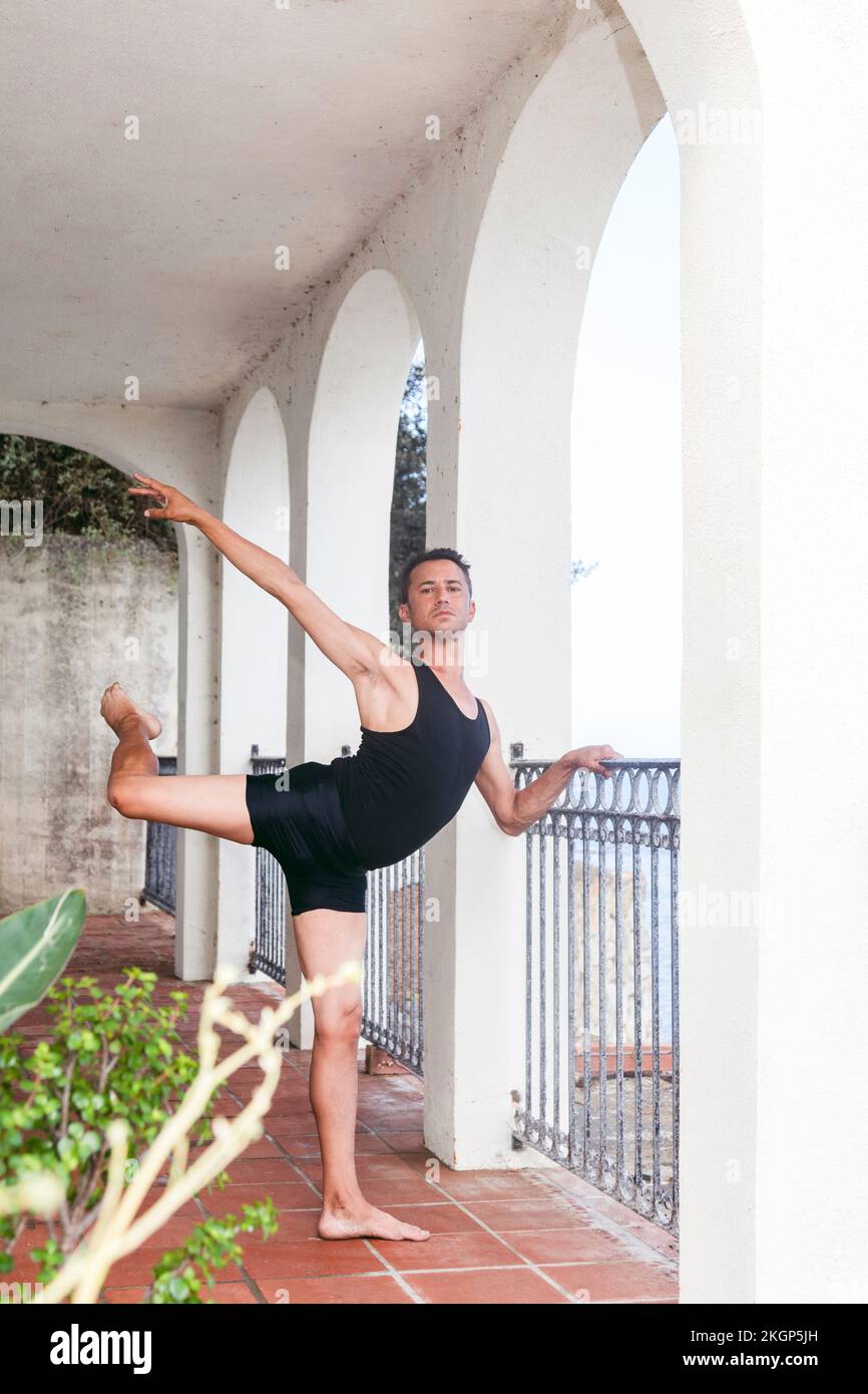 Male dancer practicing by railing on porch Stock Photo - Alamy