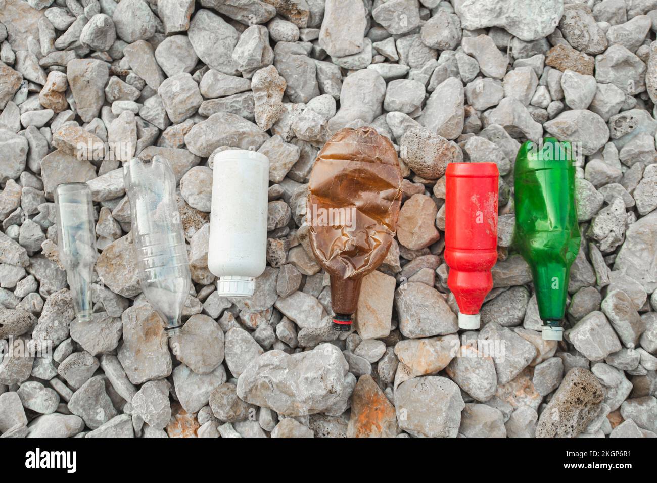Empty plastic bottles on stones at beach Stock Photo - Alamy