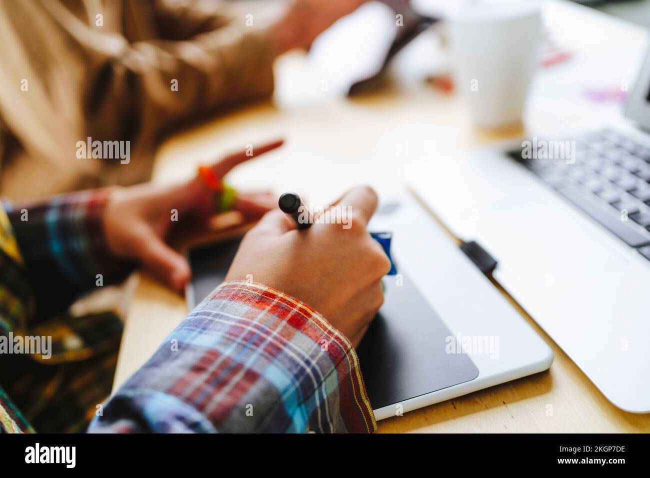 Hands of illustrator using graphics tablet by laptop at desk Stock ...