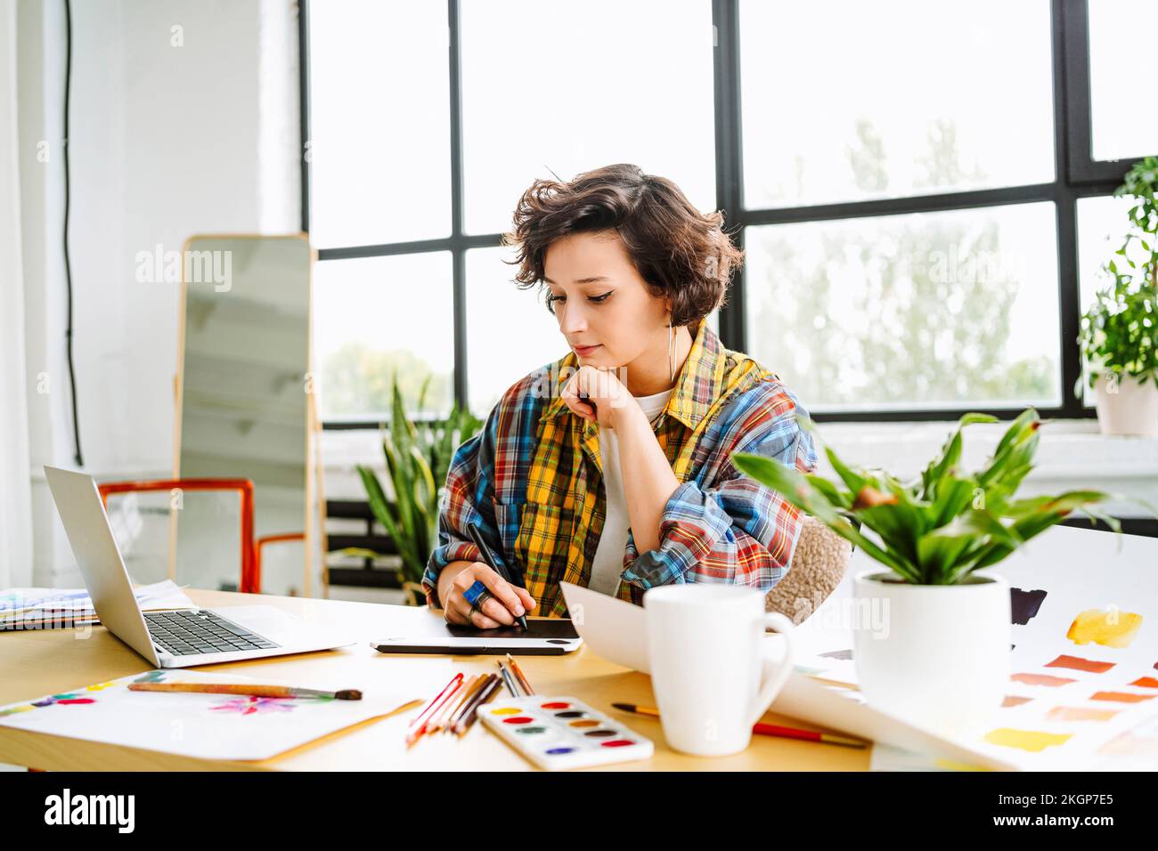 Illustrator with graphics tablet working at desk Stock Photo - Alamy