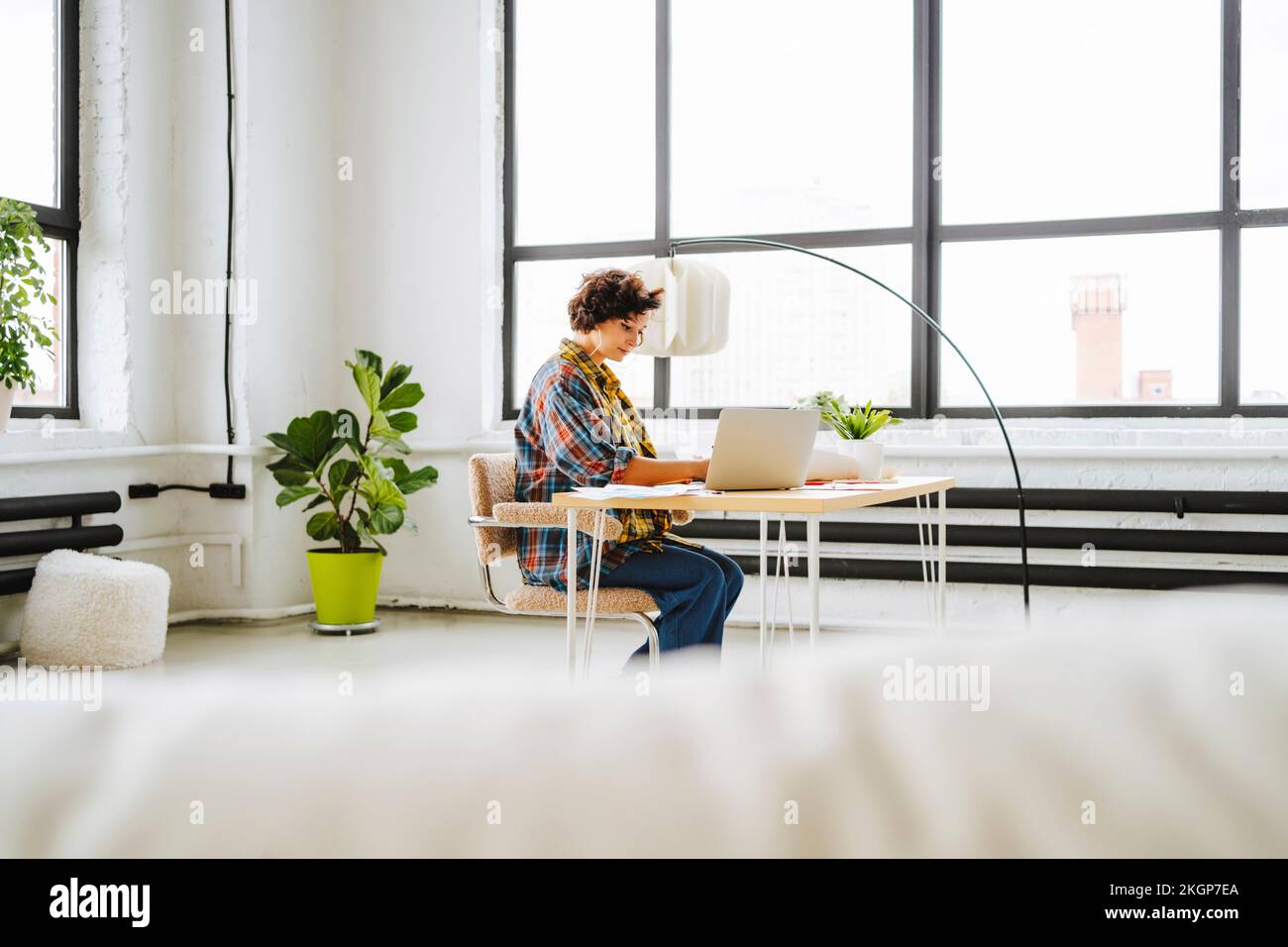 Illustrator working at desk in front of window at office Stock Photo ...