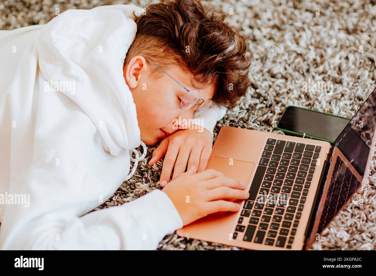 Boy sleeping in front of laptop on carpet Stock Photo - Alamy
