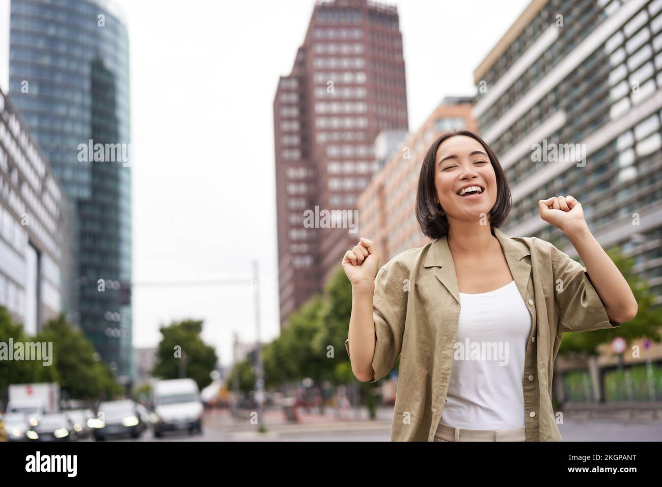 Portrait of happy asian woman, dancing and feeling joy, triumphing ...